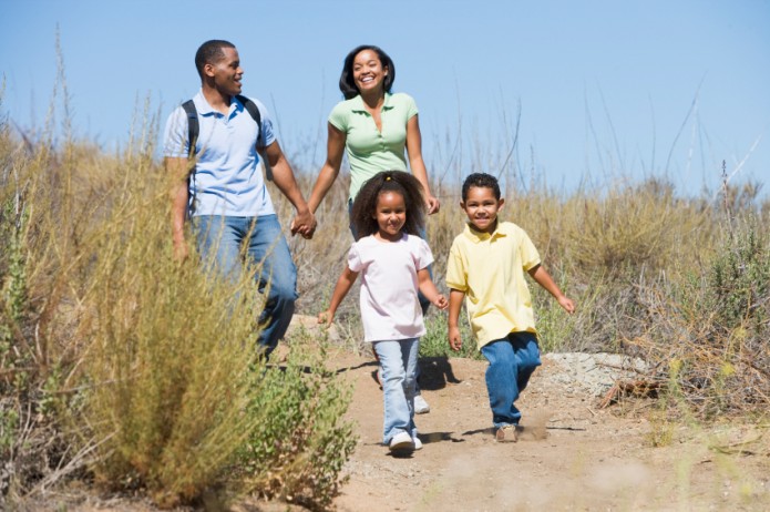 Family walking on path holding hands and smiling | Healthy Headlines